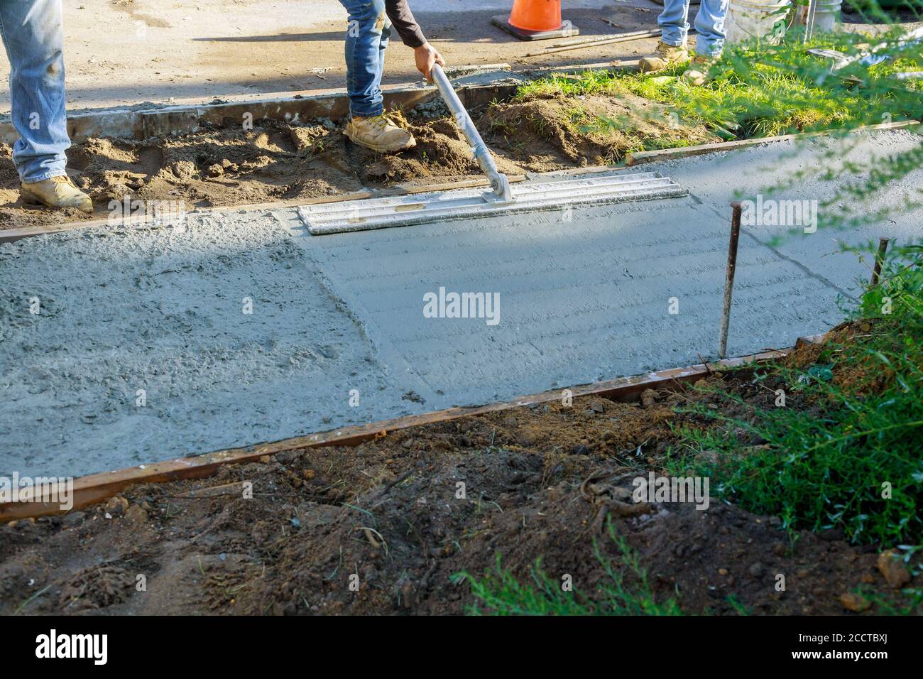 Construction mason building a screed coat cement a laborer floats a new ...