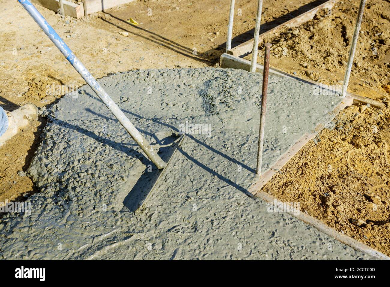 Laying down new sidewalk in wet concrete on freshly poured sidewalks ...