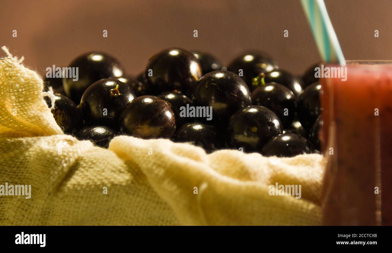Fresh fruit and glass of jaboticaba juice. Jabuticaba is a fruit ...