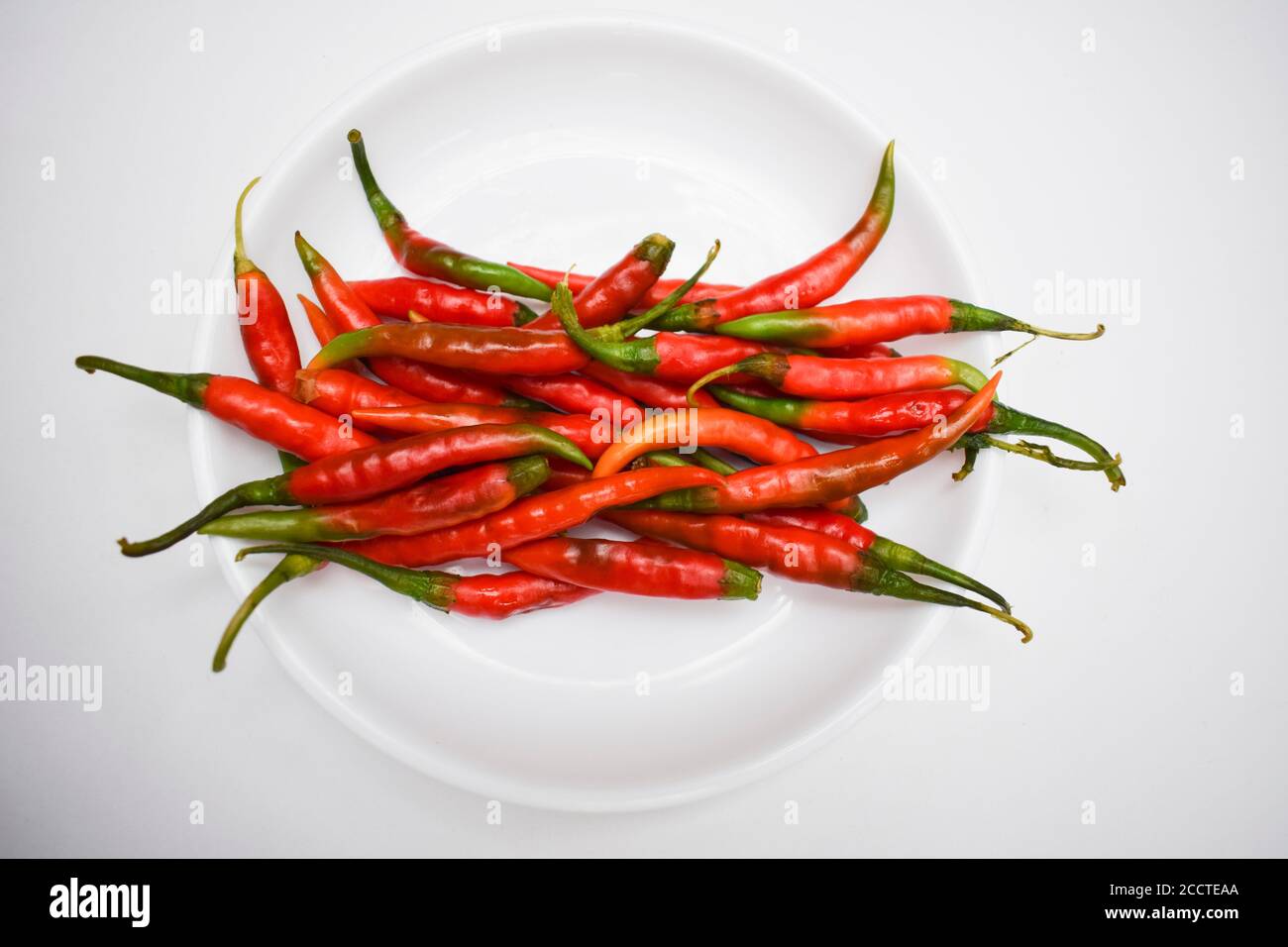 Fresh green chillies turned in to red ripe red chilly with green stem ...
