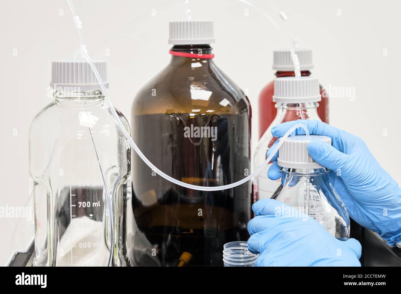 Close up womans hand changing a mobile phase solution in HPLC system ...
