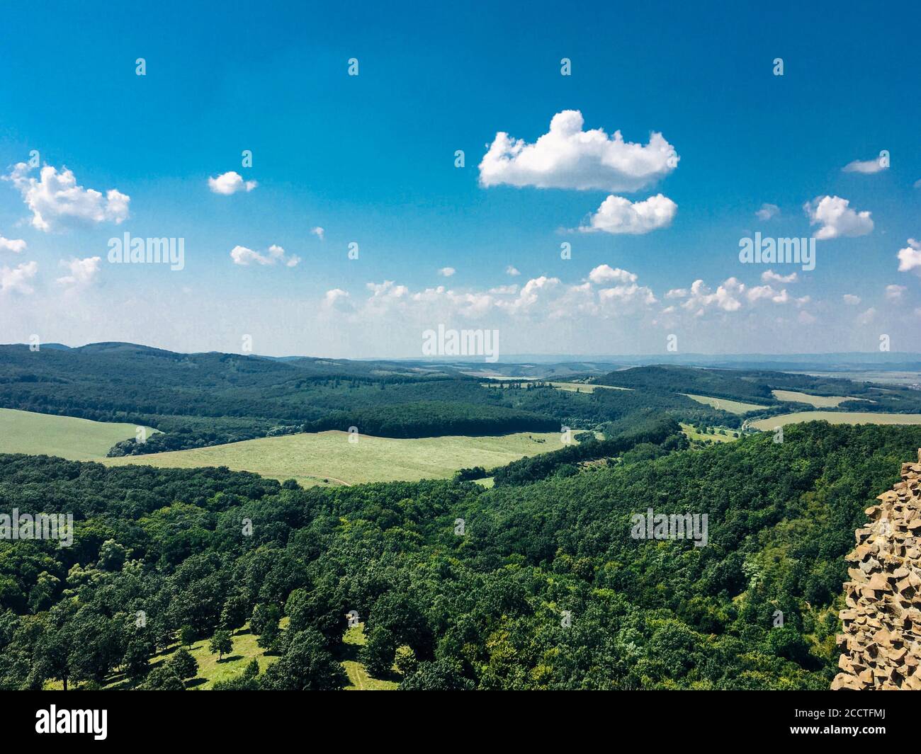 Scenic landscape in Holloko, Hungary. Green forest and blue sky with ...