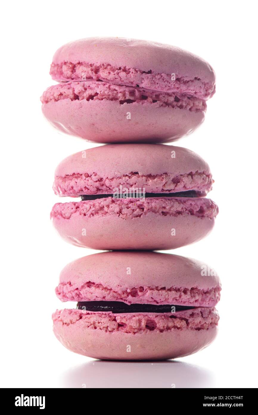 Three raspberry flavoured macaroons standing on top of each other on ...