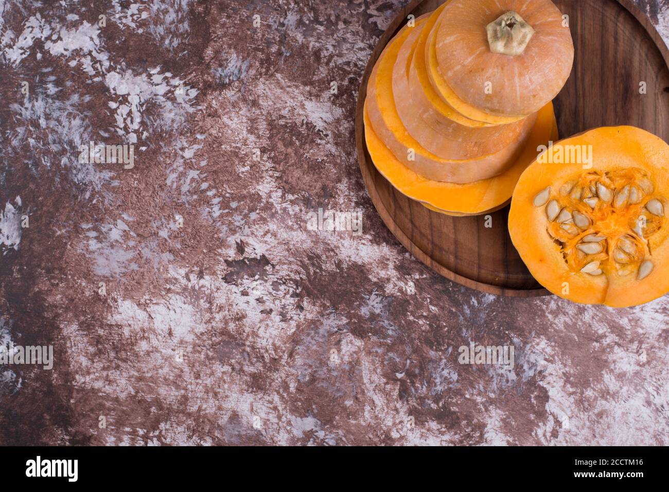 Circle sliced pumpkin in a wooden platter on the top corner Stock Photo ...
