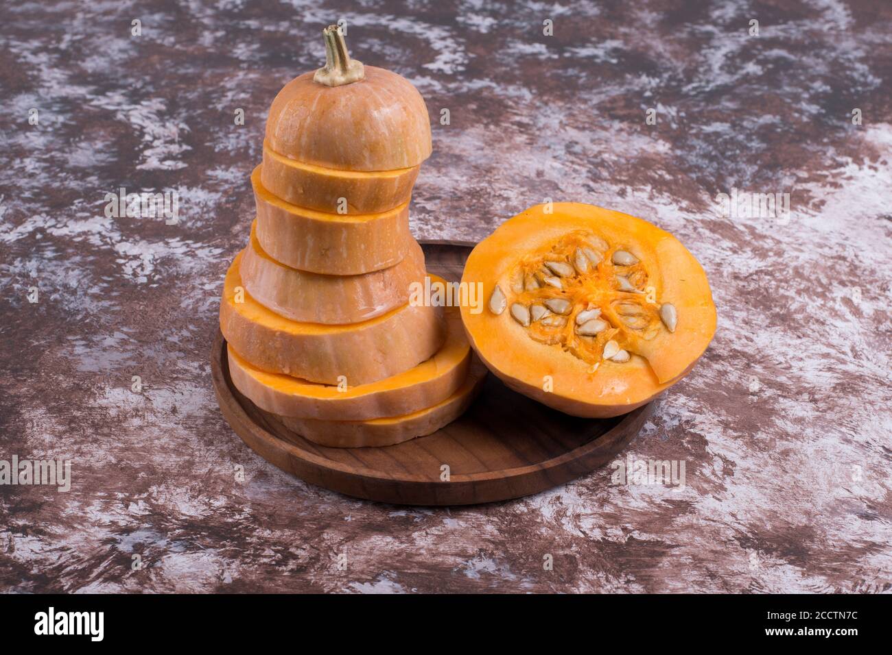 Circle sliced pumpkin in a wooden platter in the middle Stock Photo - Alamy