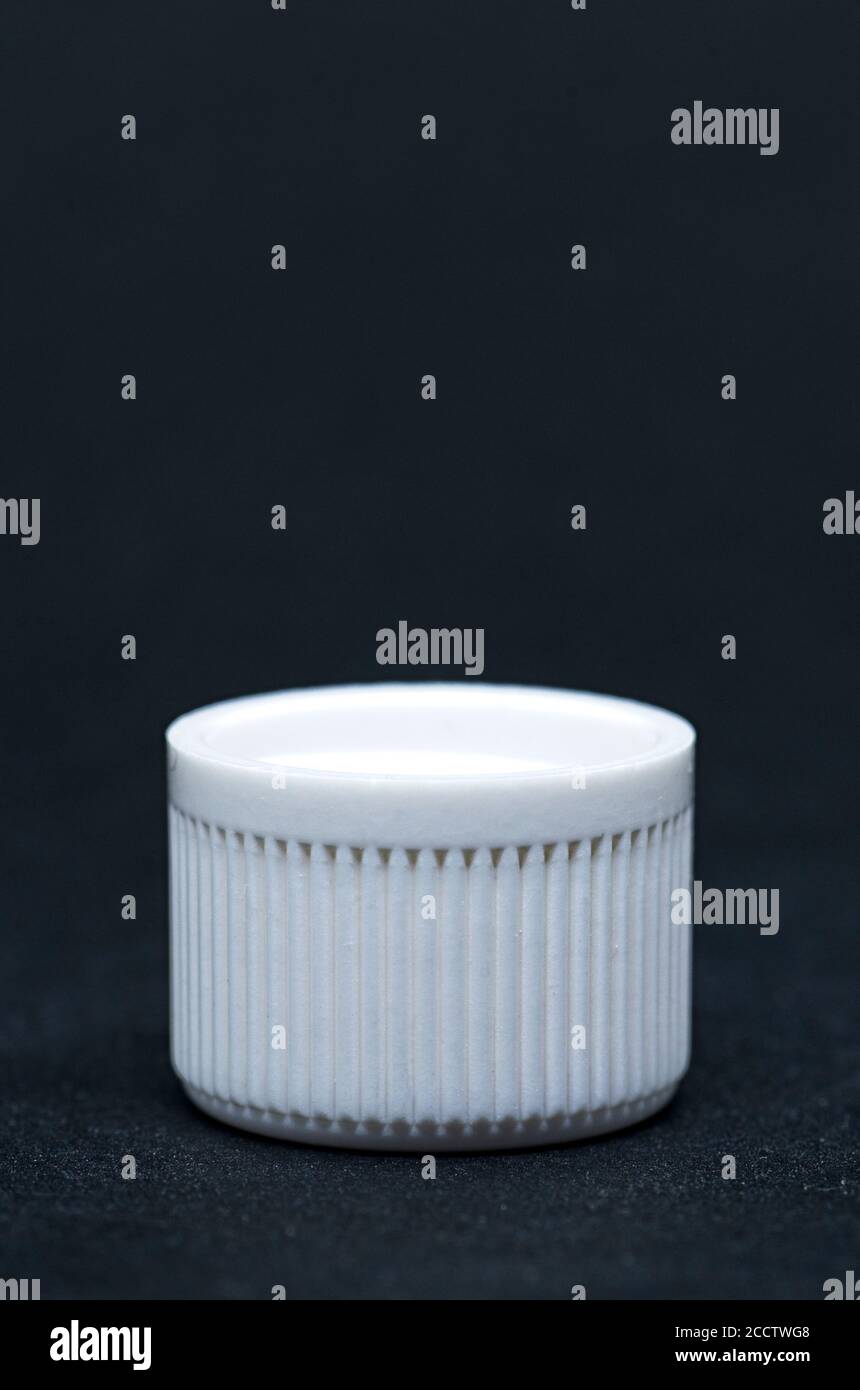Plastic white cap on black background. Manufactured object Stock Photo ...