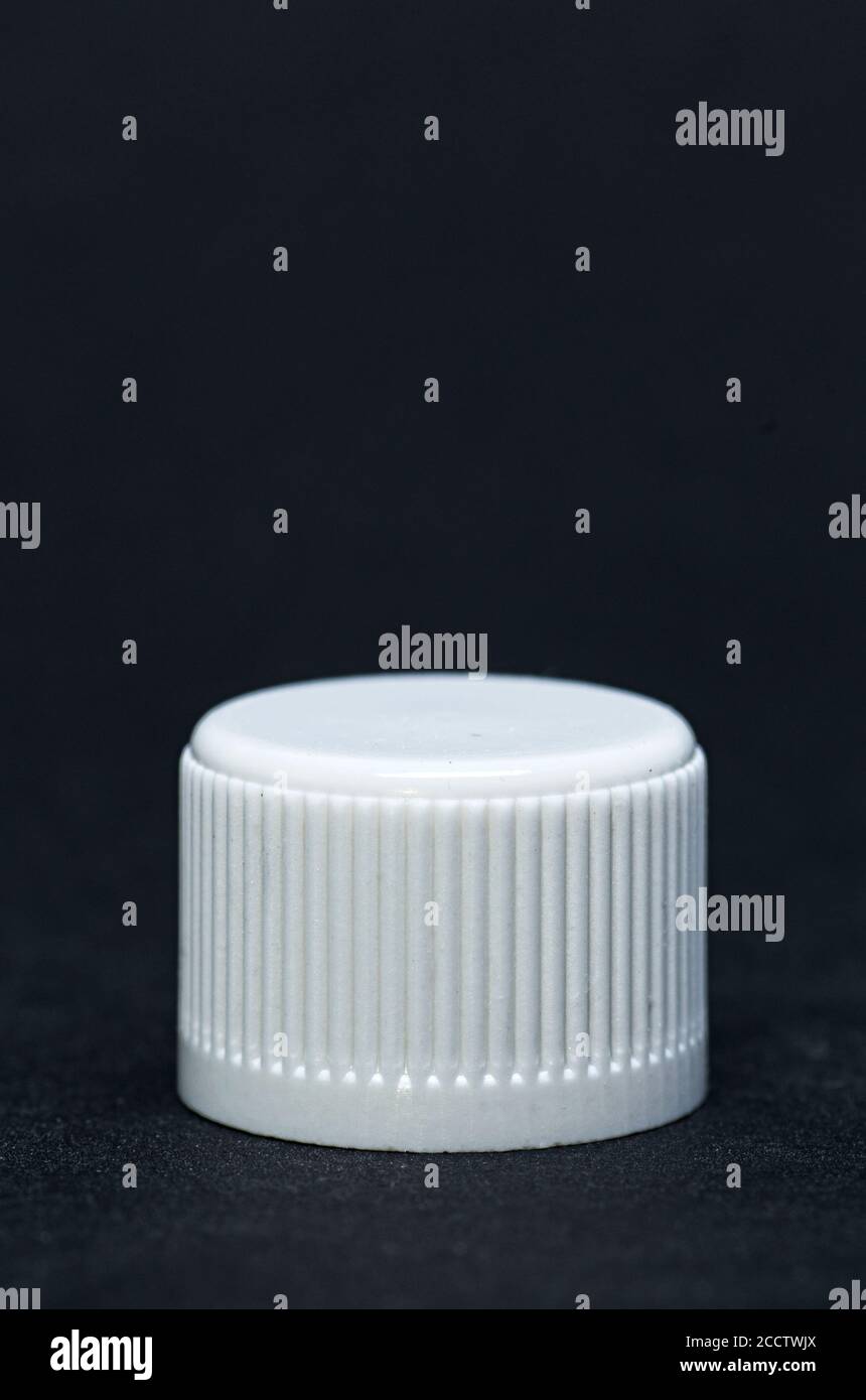 Plastic white cap on black background. Manufactured object Stock Photo ...