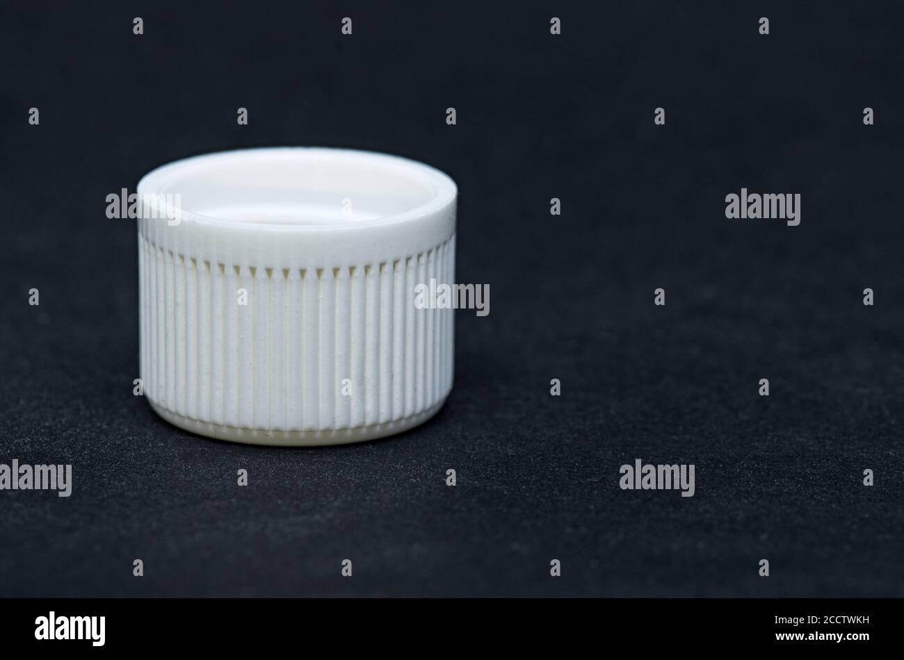 Plastic white cap on black background. Manufactured object Stock Photo ...