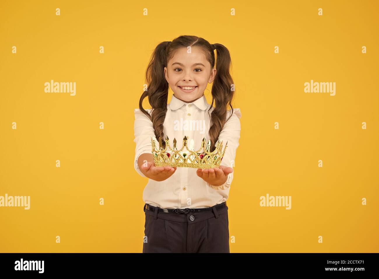 Best student prize reward. Happy small child giving out crown reward on ...