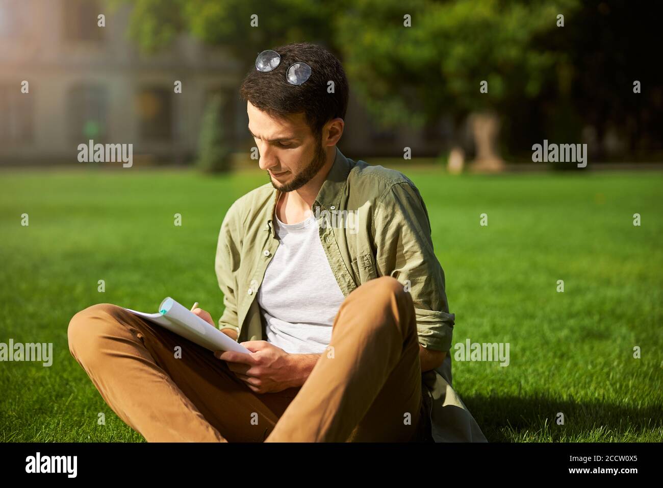 Focused young man writing with a pencil Stock Photo - Alamy