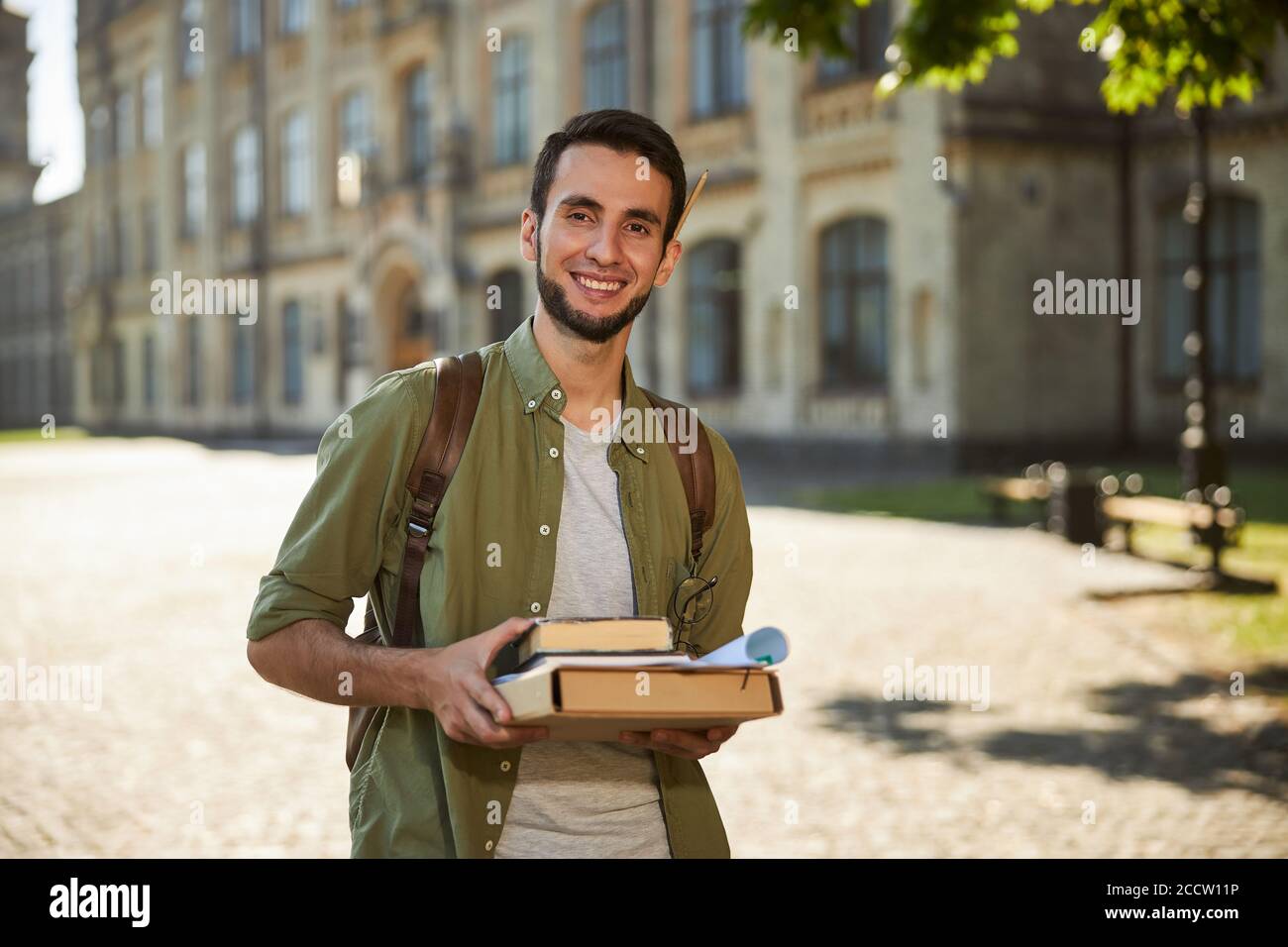 Handsome student holding books with both hands Stock Photo - Alamy