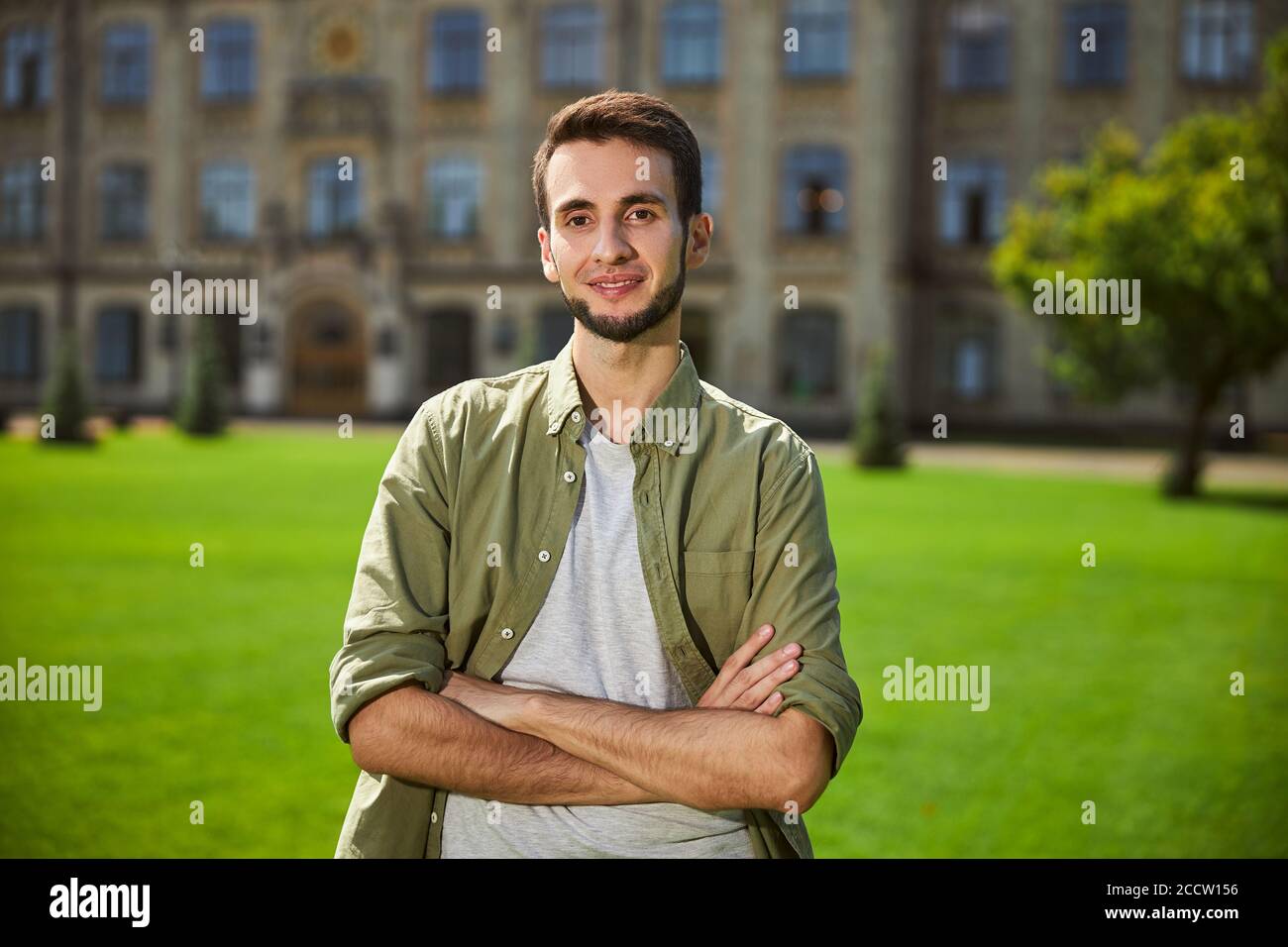 Male student with crossed arms looking ahead Stock Photo - Alamy