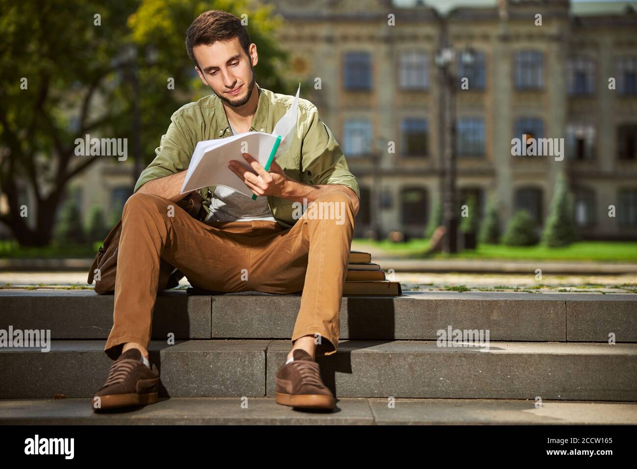 Focused university student doing his homework outside Stock Photo - Alamy
