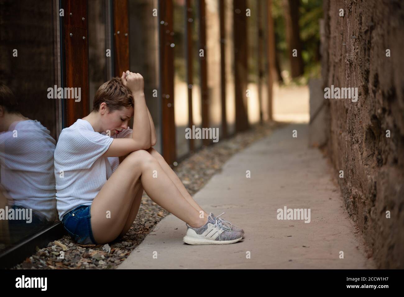Thoughtful and sad girl. Portrait of one woman with short hair looking ...