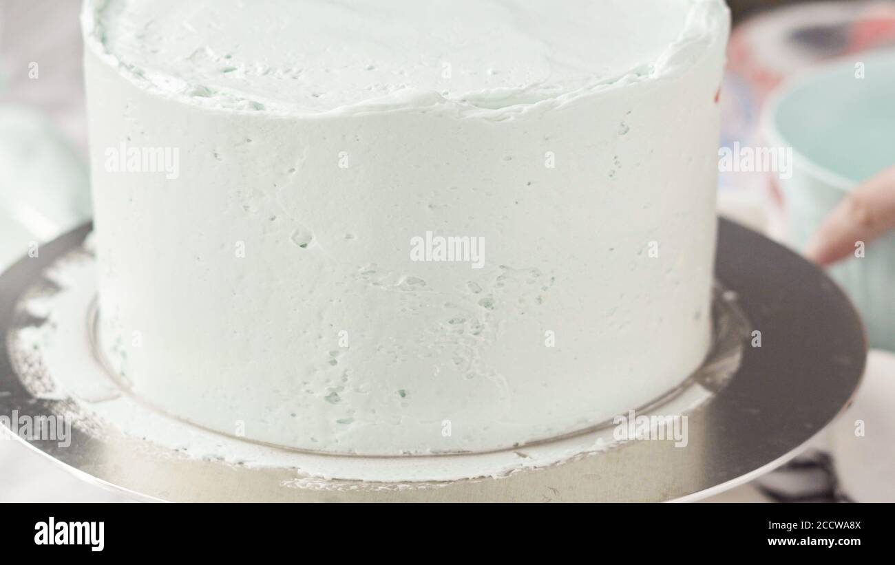 Frosting round three-layer vanilla cake with buttercream frosting Stock ...