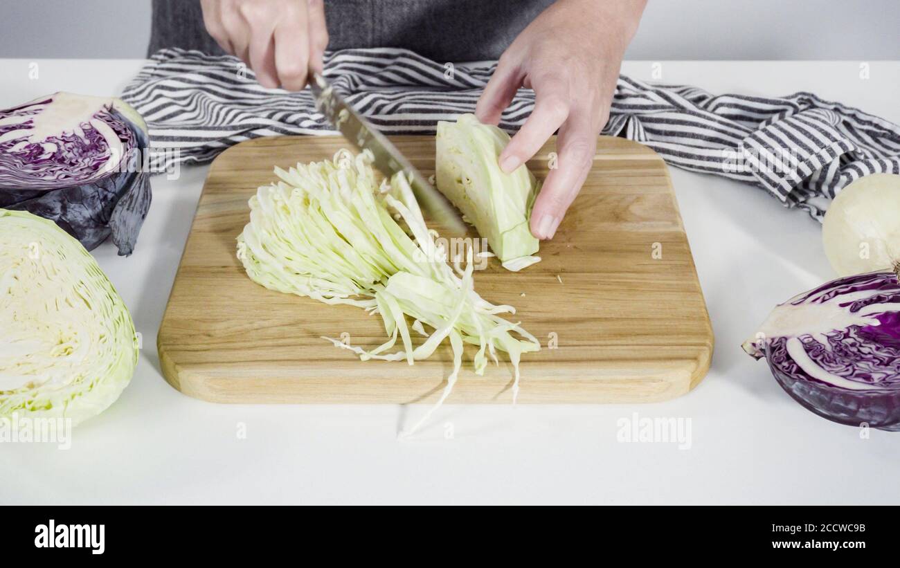 Step by step. Shredding organic cabbage on a wood cutting board Stock ...