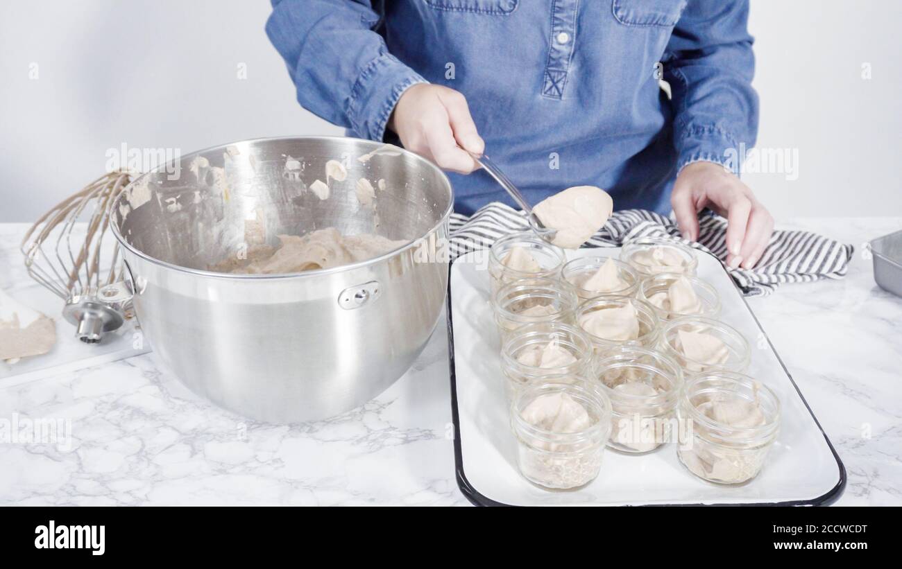 Step by step. Scooping homemade chocolate ice cream into glass jars ...