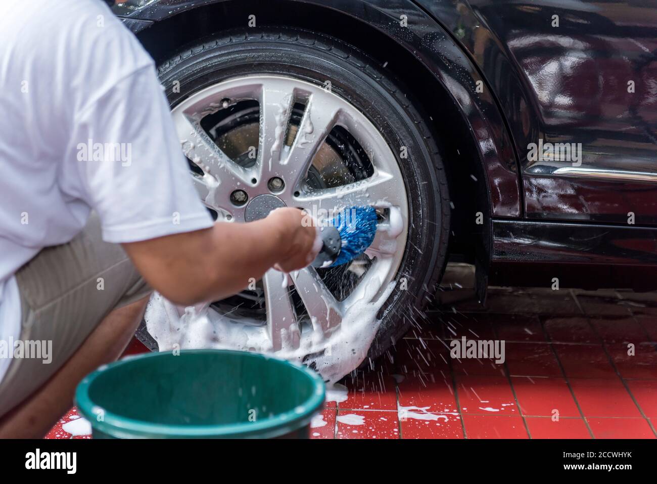 Man cleaning the car wheels in the garage Stock Photo - Alamy