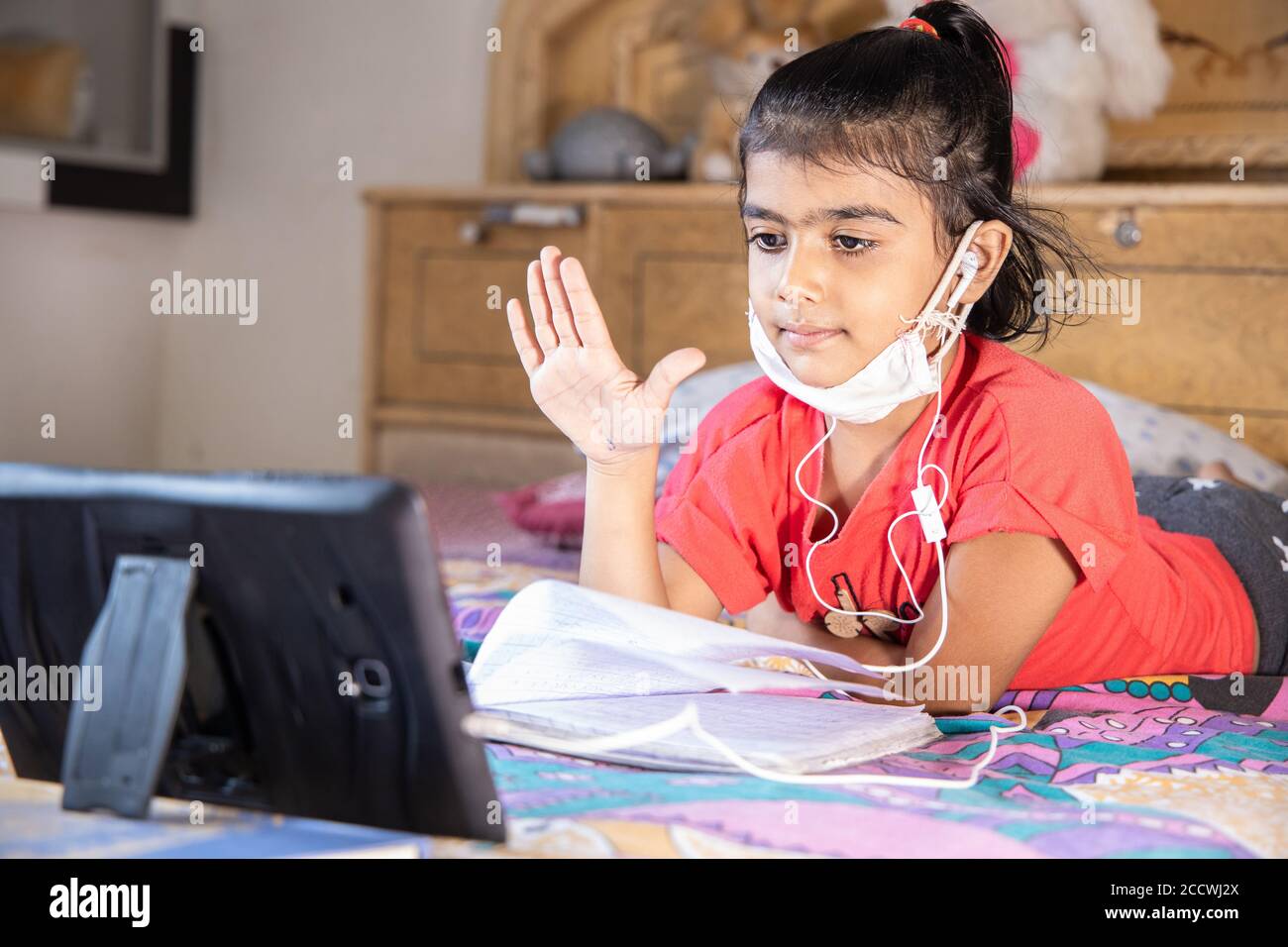 Little girl kid student raise her hand while studying online class with ...