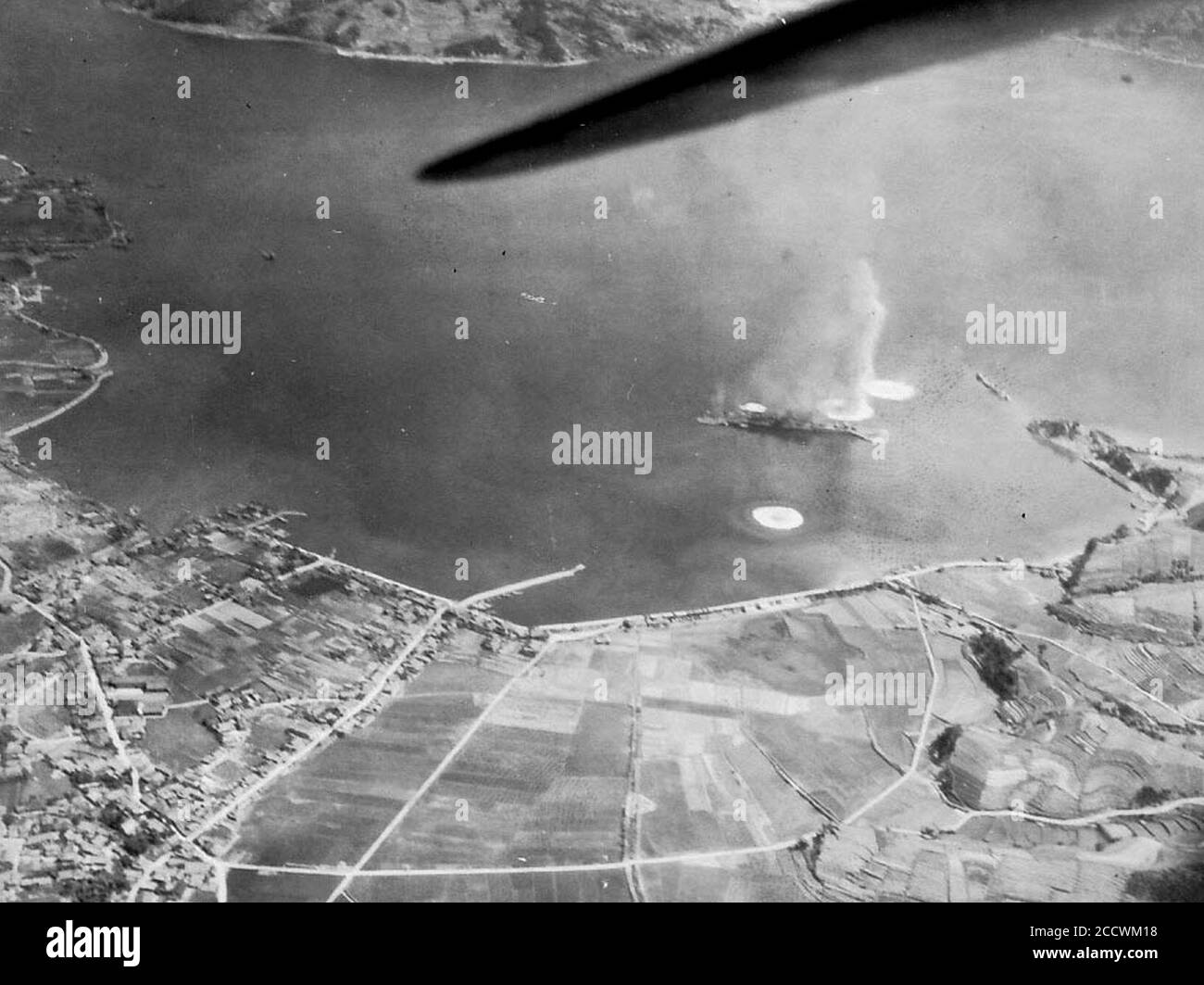 Japanese ship under attack by U.S. Navy carrier aircraft at Kure, Japan ...