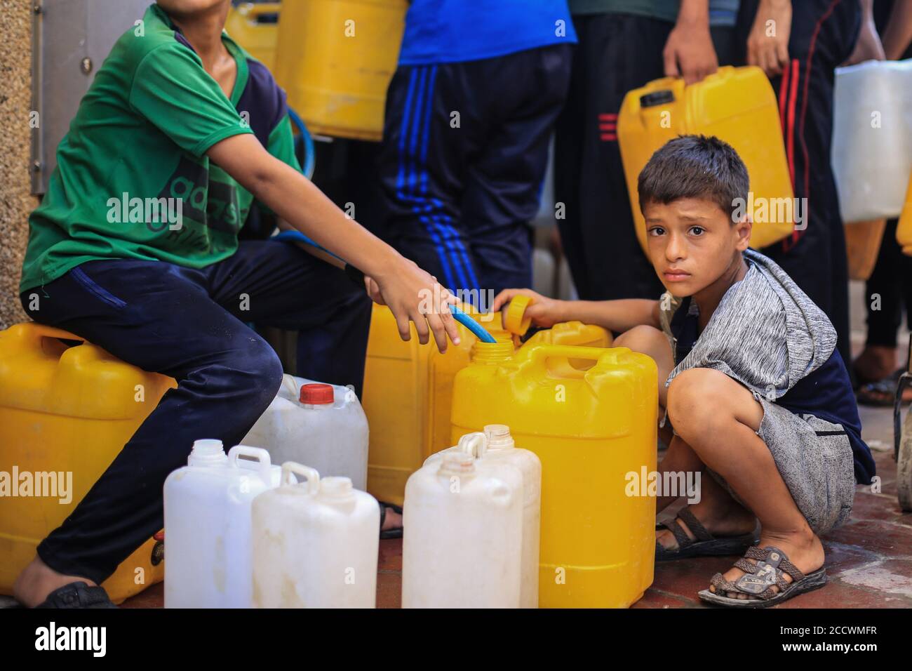 Gaza. 24th Aug, 2020. Children wait to fill bottles with drinking water ...