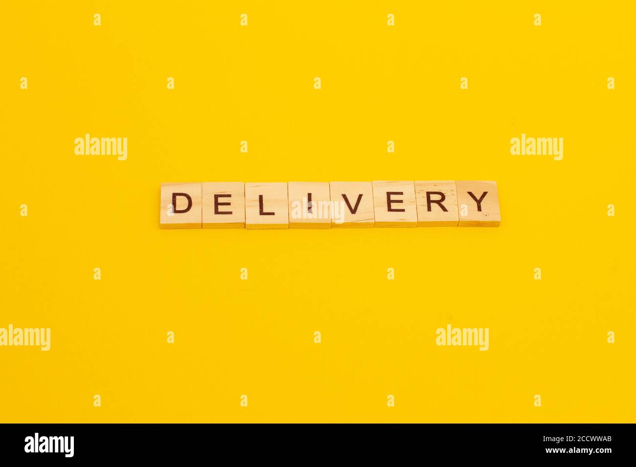 Word DELIVERY made from wooden cubes on yellow background Stock Photo ...