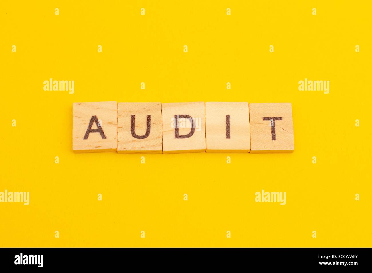 Word AUDIT made from wooden cubes on yellow background. Business ...