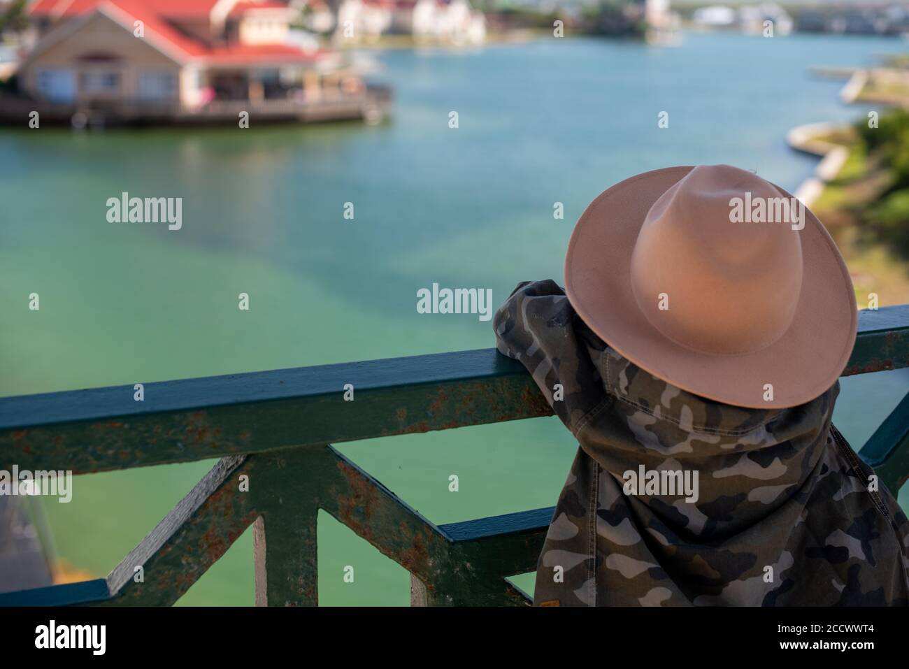 Rear view of young boy watching river Stock Photo - Alamy
