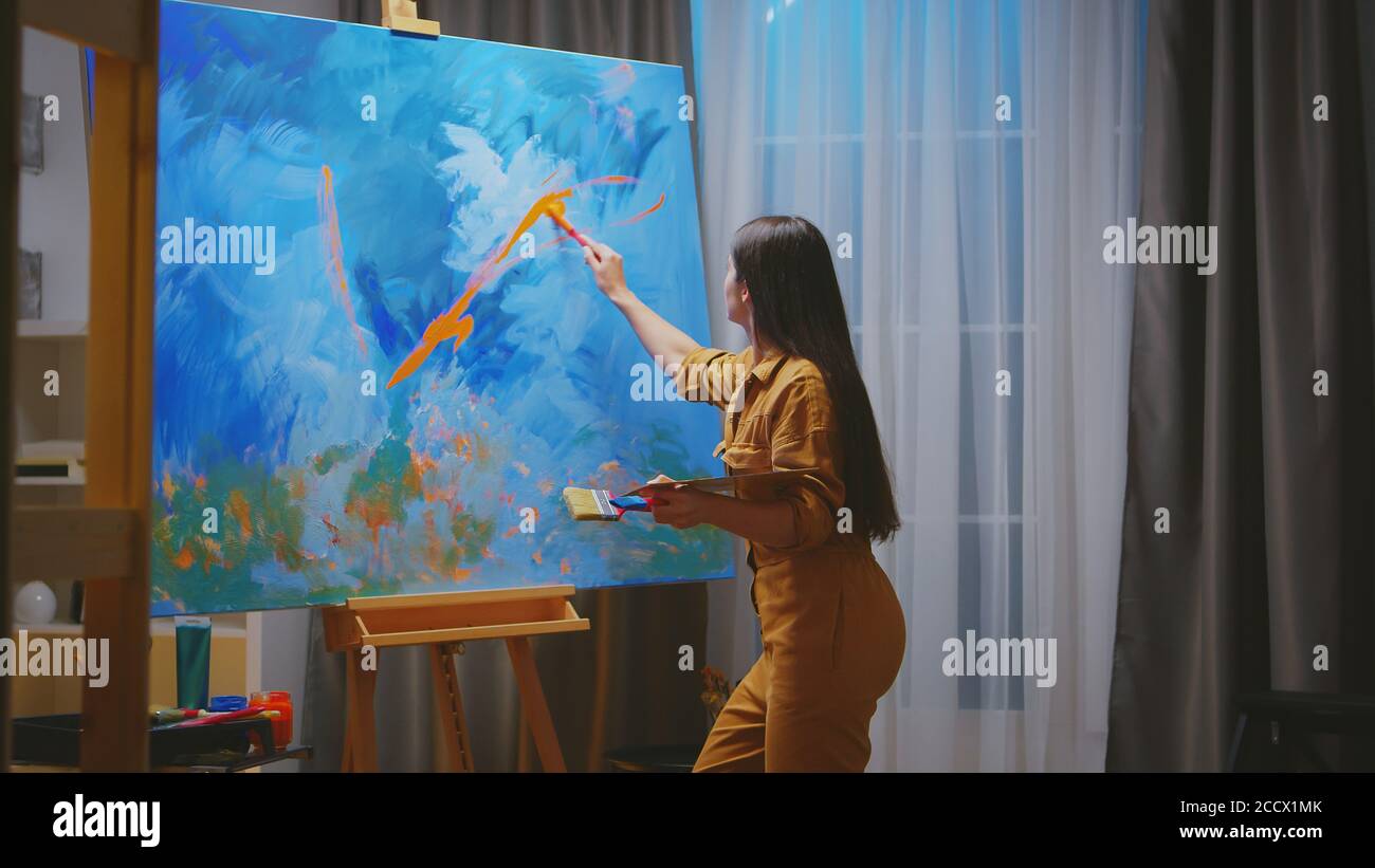Talented young painter using different color on canvas Stock Photo - Alamy