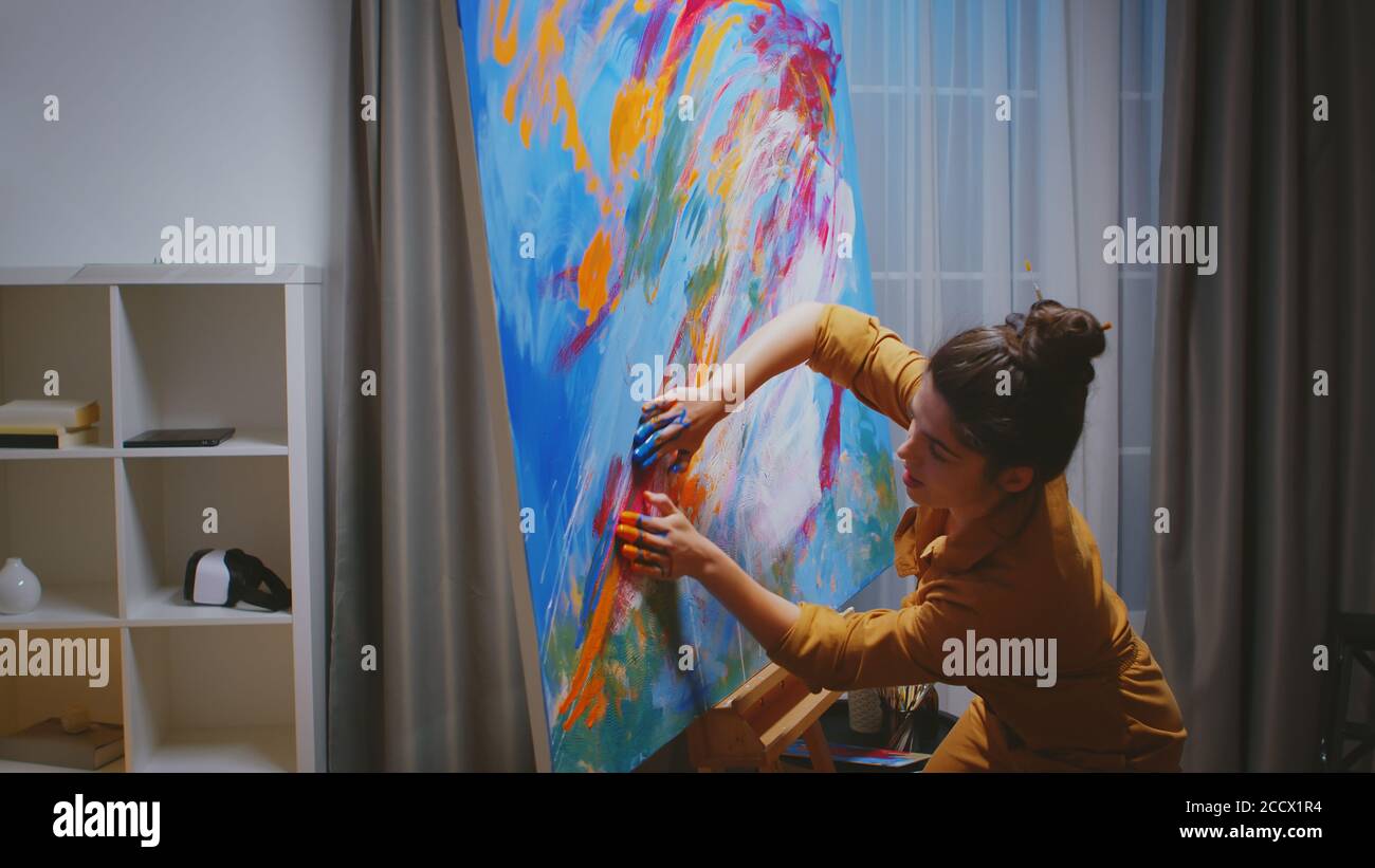 Painter making a masterpiece with her fingers in art studio for art ...