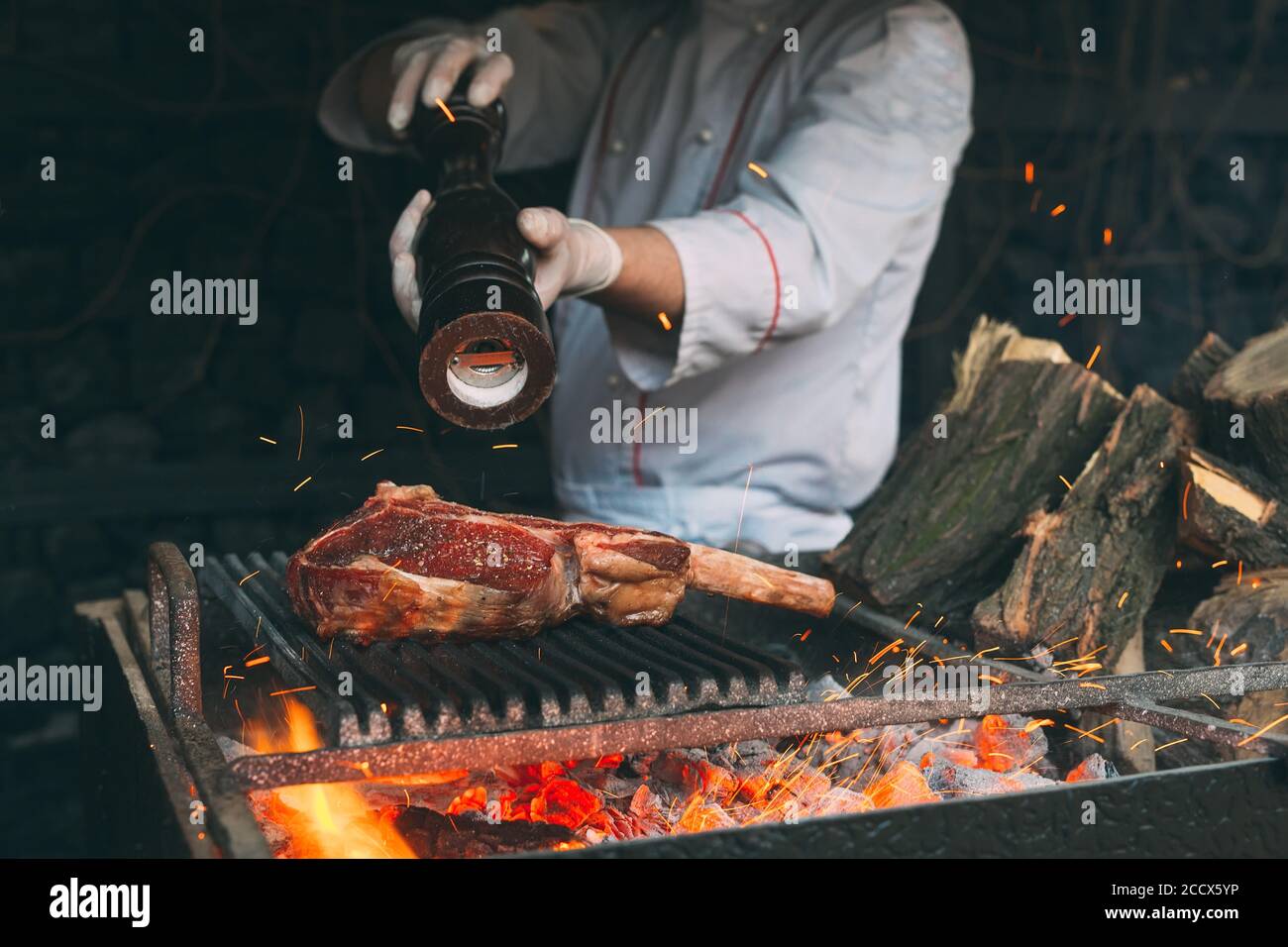 Chef pepper the steak on a fire Stock Photo - Alamy