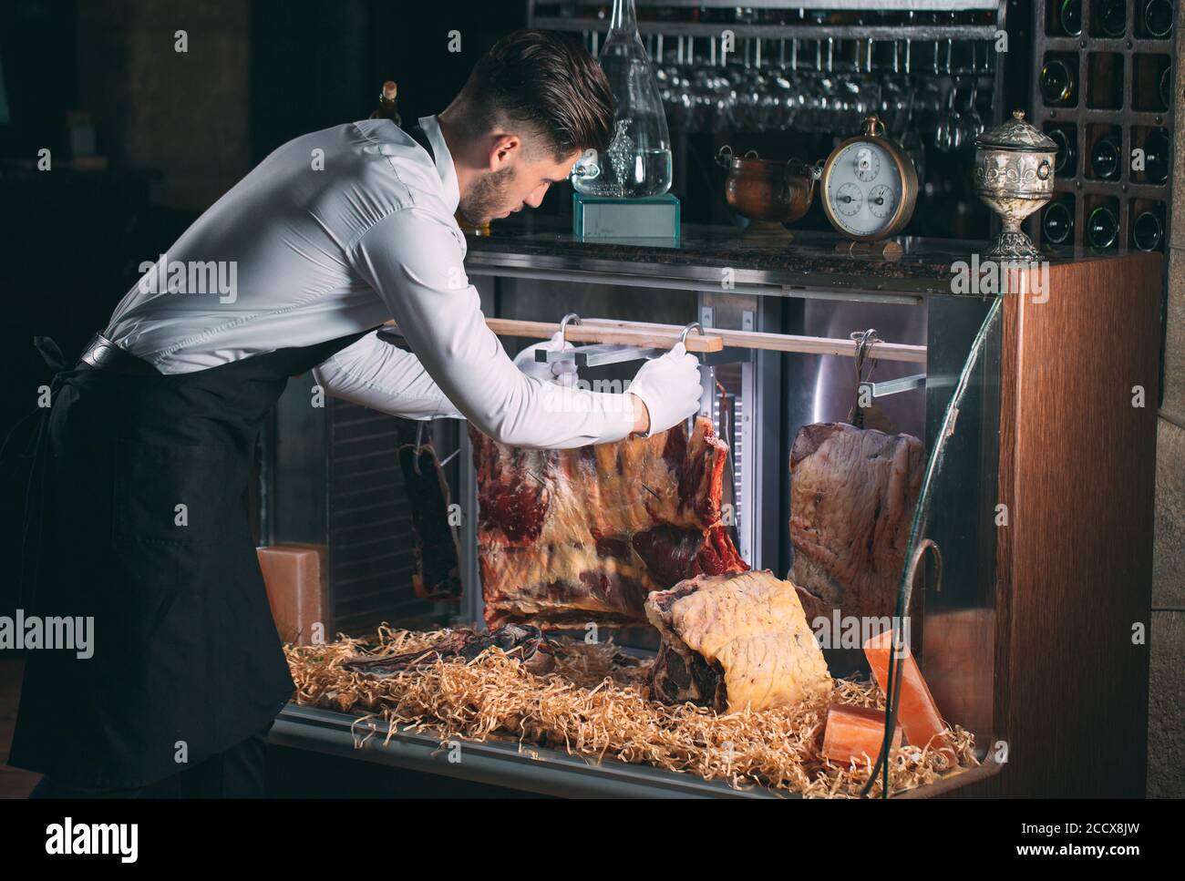 The waiter or cook gets dry meat in the refrigerator Stock Photo - Alamy