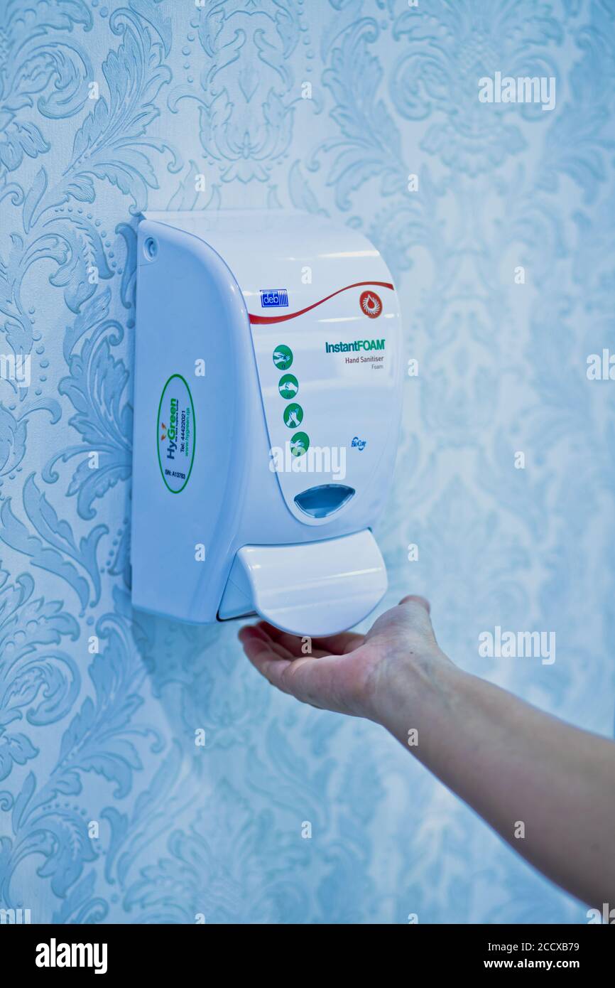 using hand sanitizer wall machine Stock Photo - Alamy