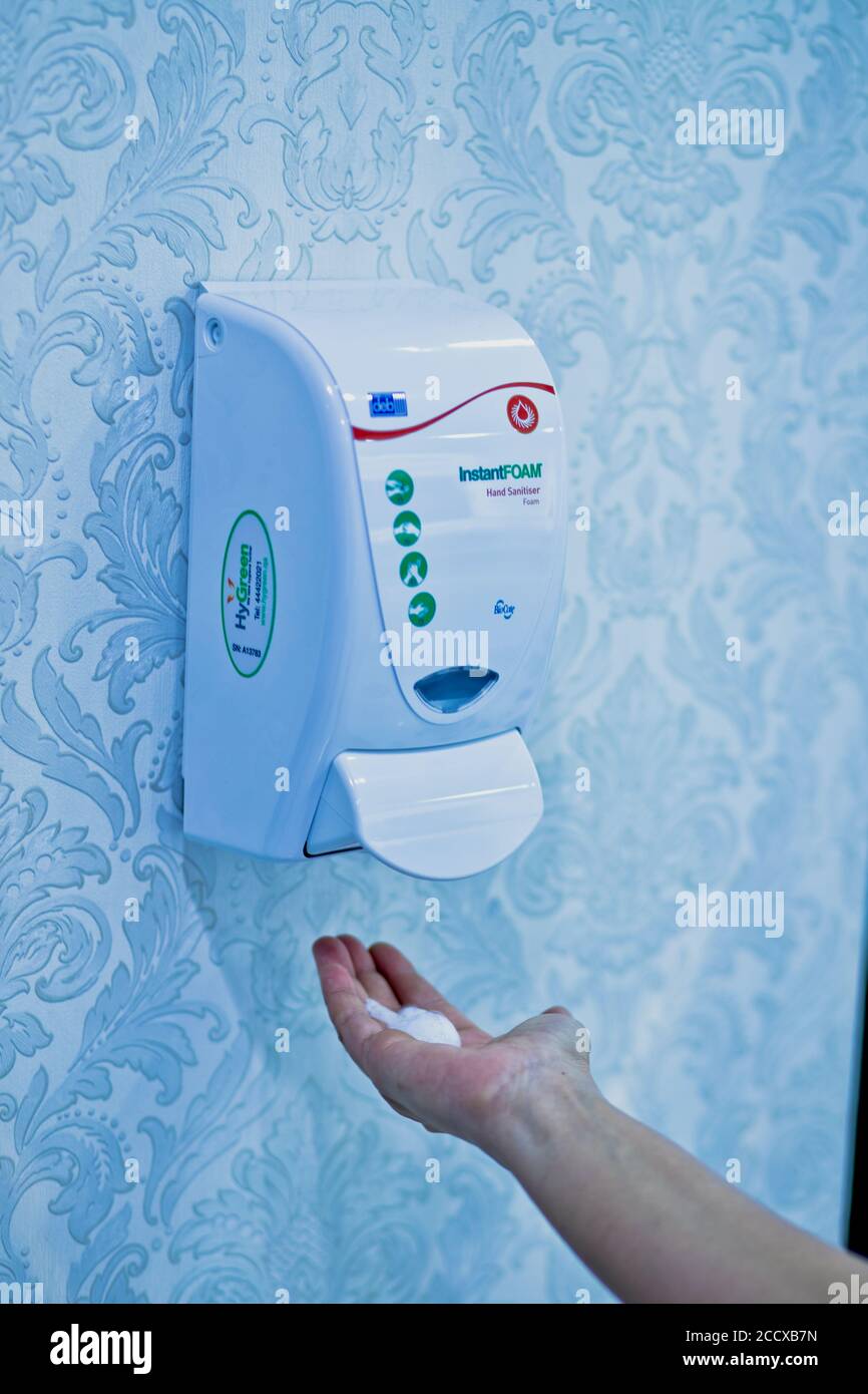 using hand sanitizer wall machine Stock Photo - Alamy