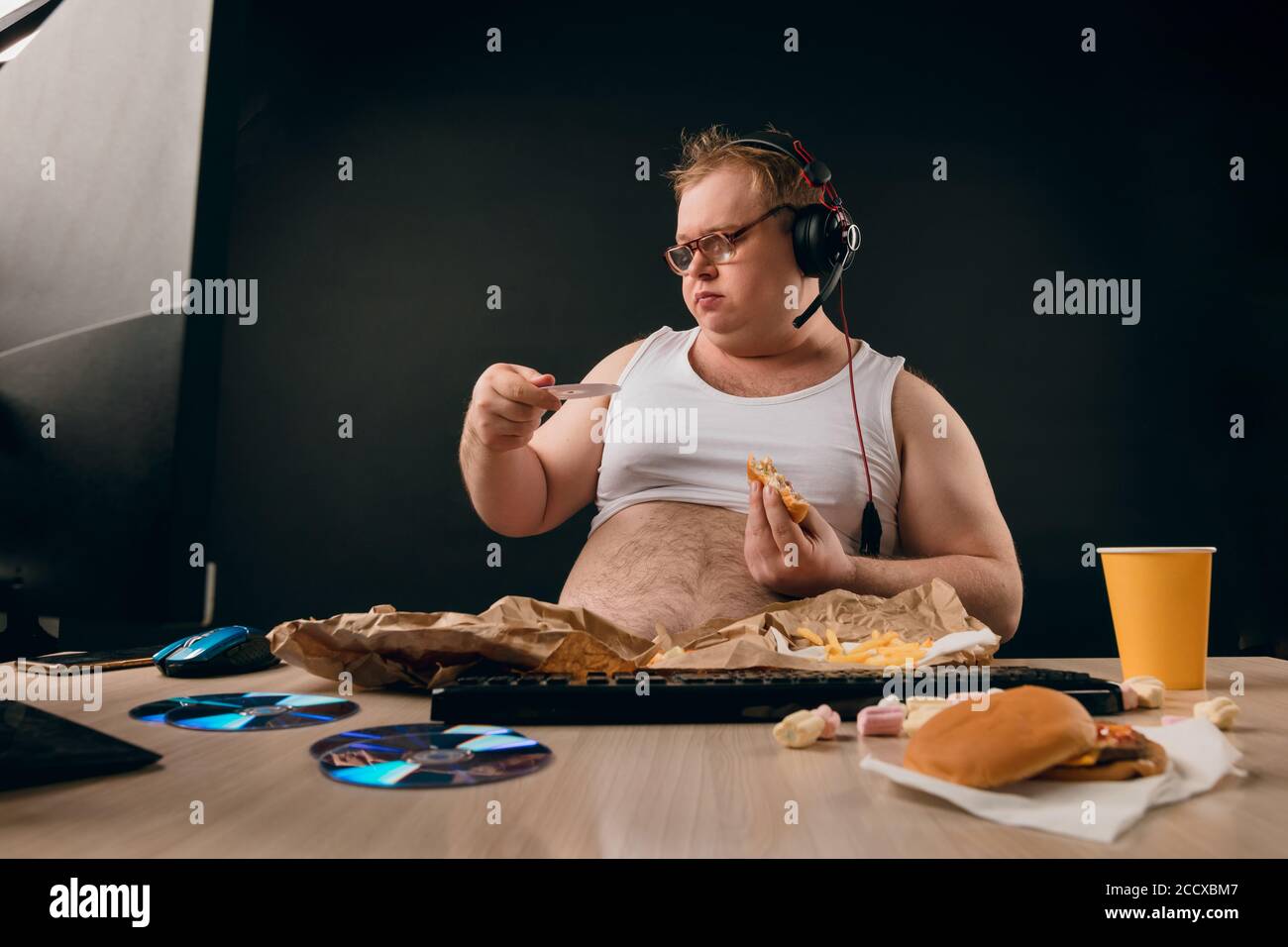 obese man choosing disk to watch it while having breakfast isolated ...