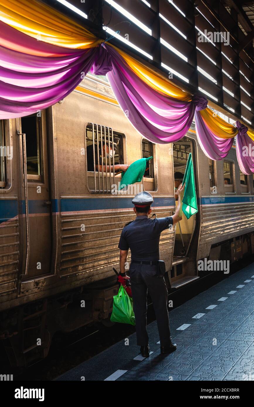 Conductor with signal flags on platform of local train station in Thon ...