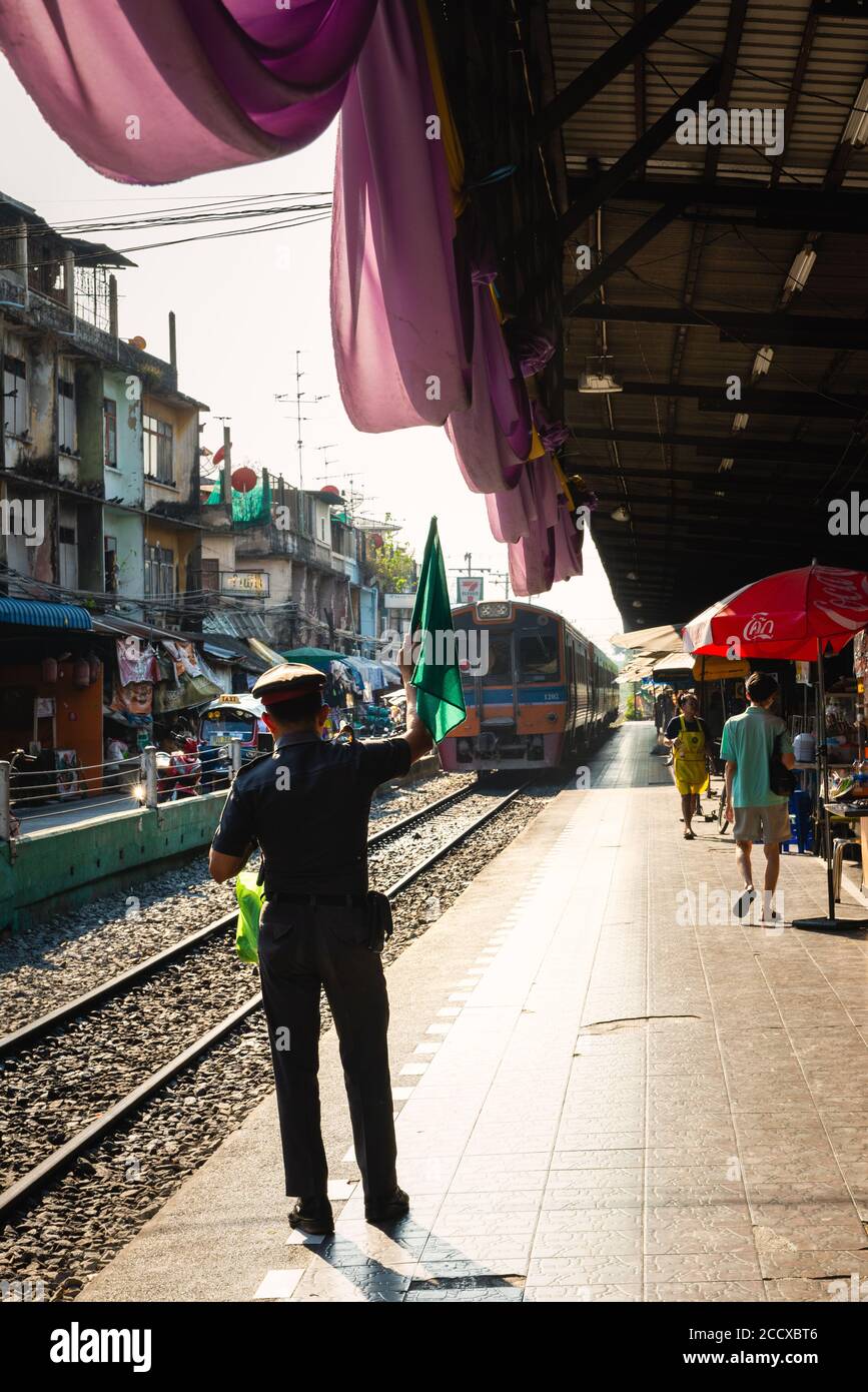 Conductor with signal flags on platform of local train station in Thon ...