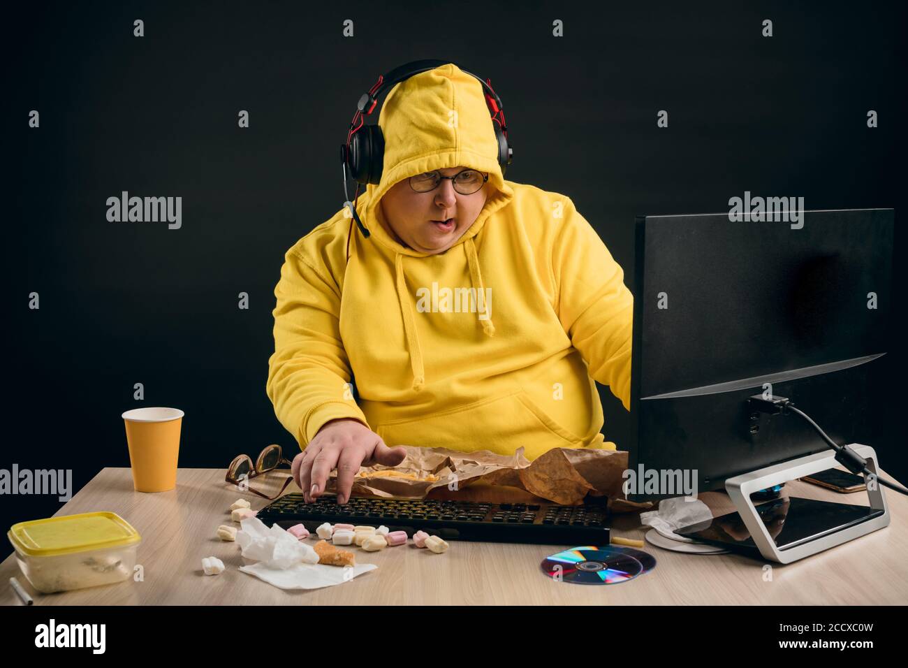 funny guy in yellow hood playing computer games with enthusiasm. spare ...