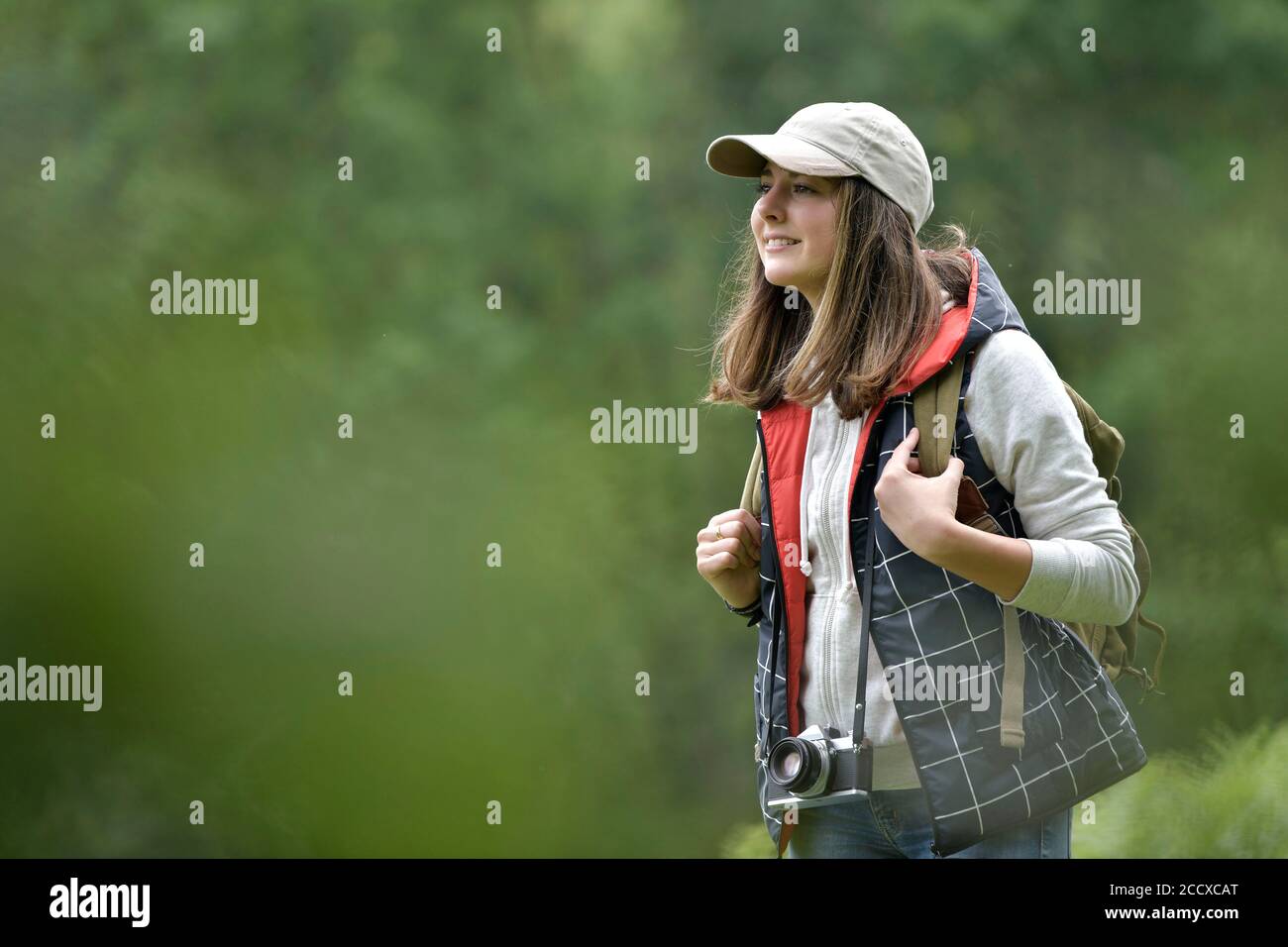 Young woman with backpack hiking in forest Stock Photo - Alamy