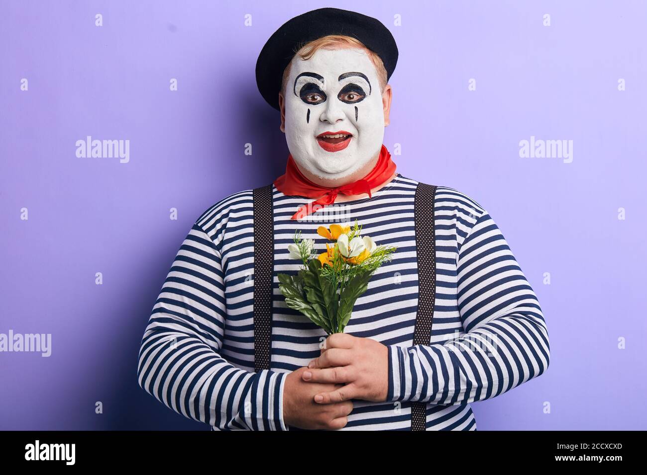 positive funny mime with a bunch of wonderful flowers posing to the ...