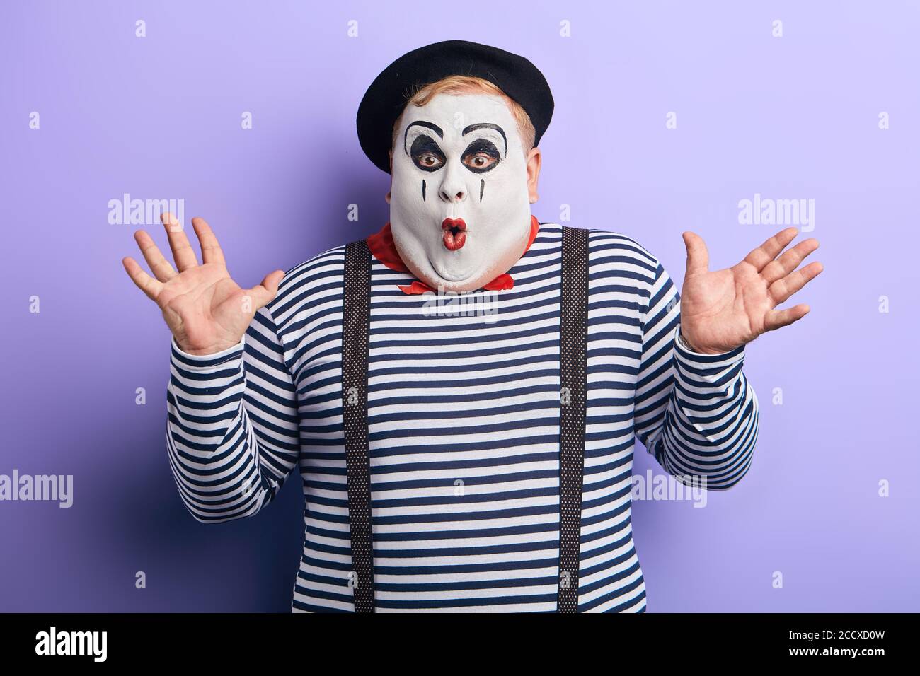 portrait of an amazed clown with painted white face, open mouth, bugged ...