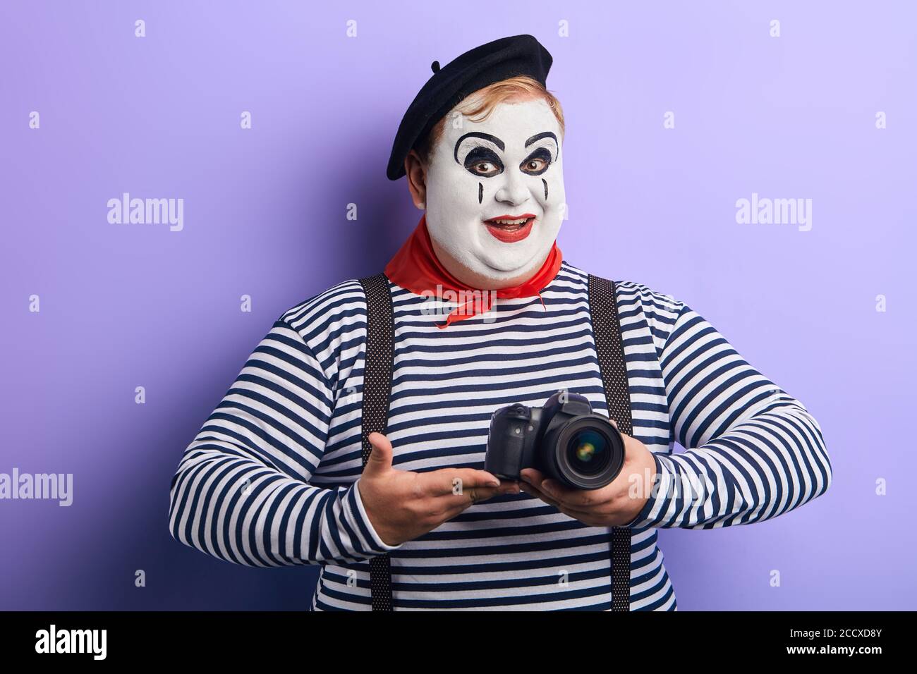 smiling pleasant mime with white face taking picture in the studio with ...