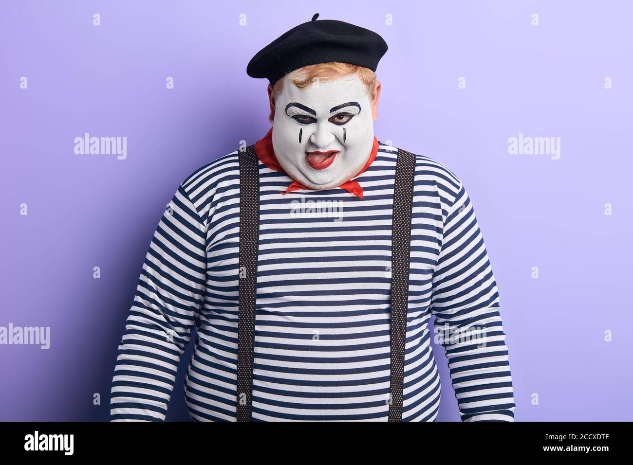 talented clown putting tongue out, trying to make children laughing ...