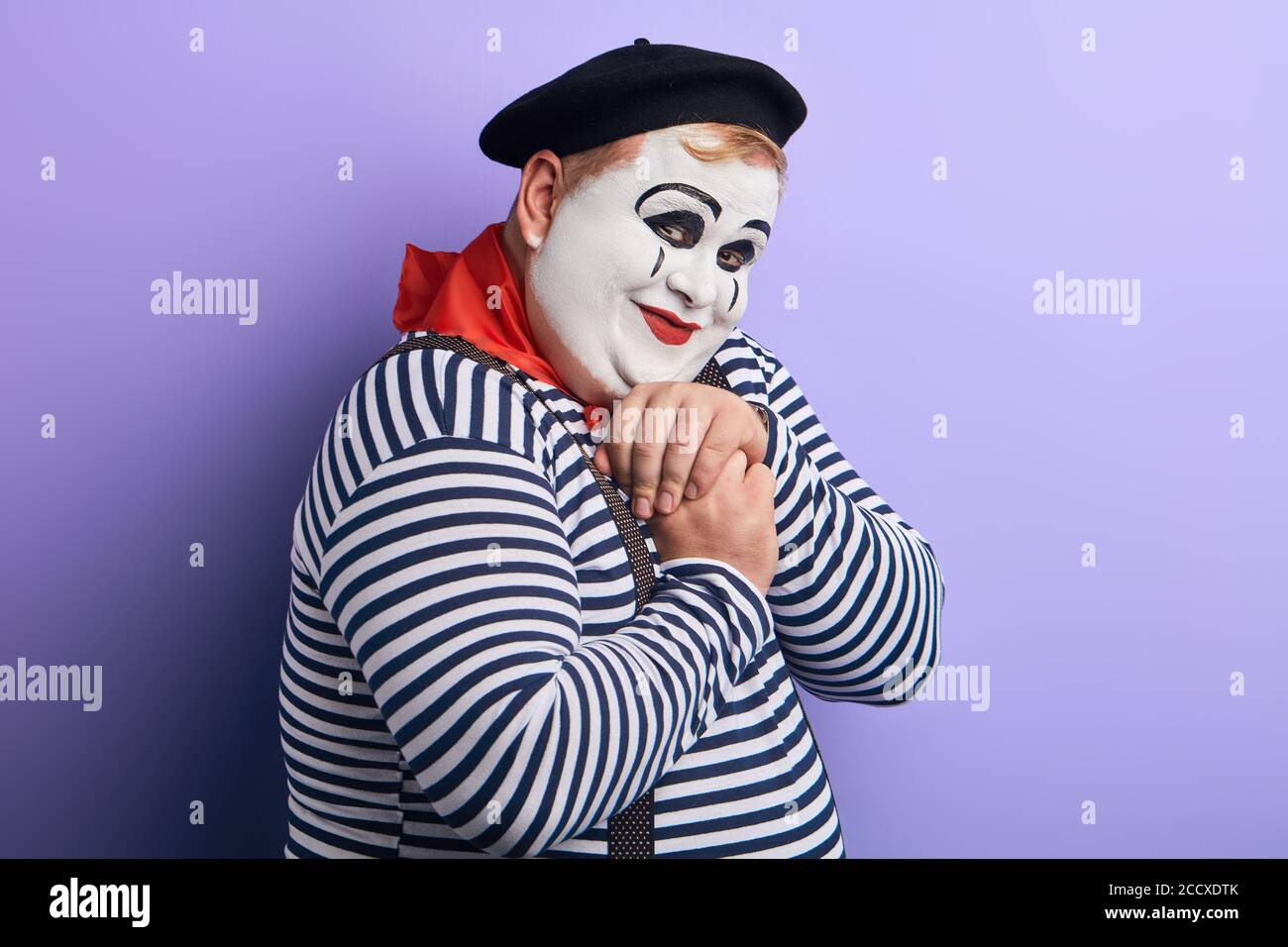 Portrait of a shy and flirty fat mime giving admiring look. Man falls ...