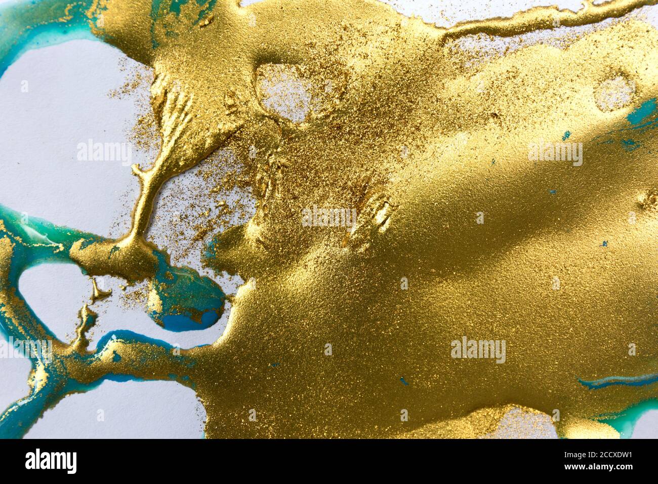 Gold and blue mixed inks splattered on white paper background Stock ...