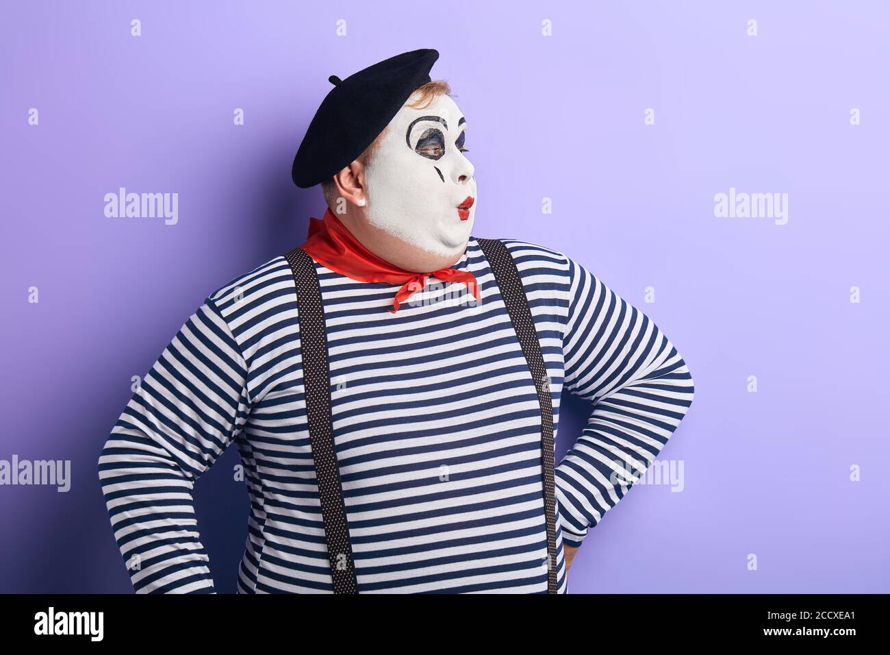 Pantomime actor with hands on the hip performing on the stage. close up ...