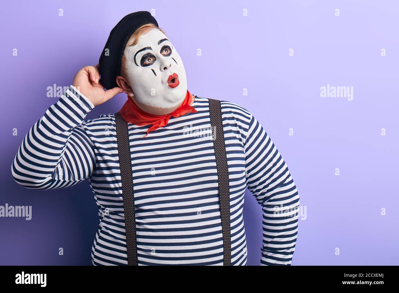 puzzled clown making decision. close up portrait.isolated blue ...