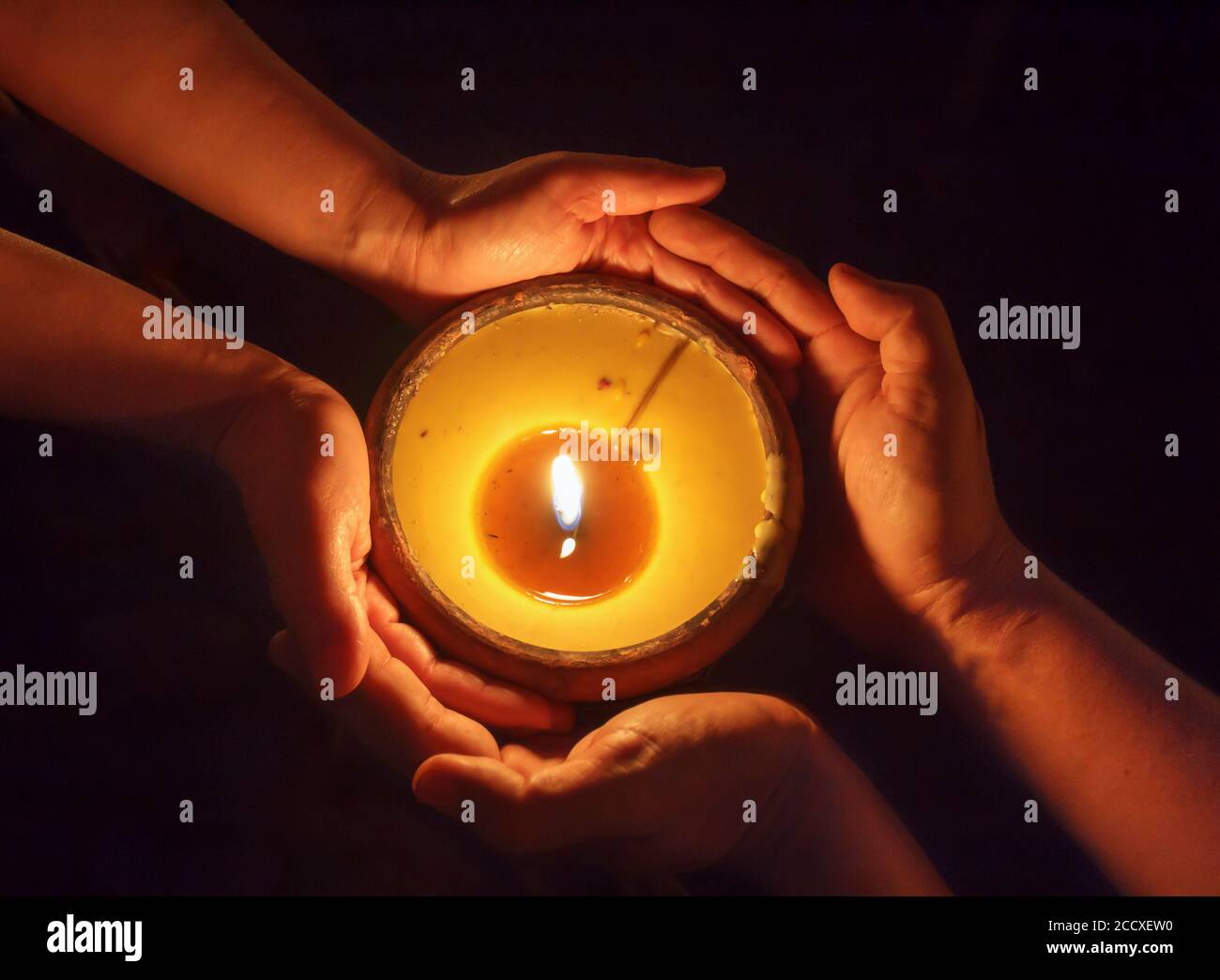Candle in the hands together Stock Photo - Alamy