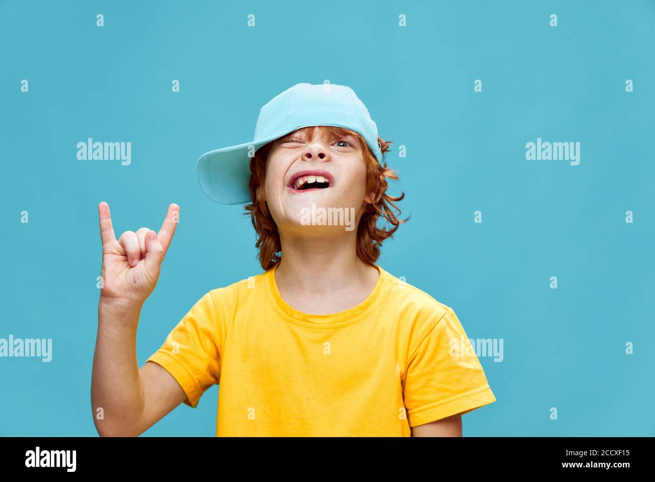 Red-haired boy with a cap on his head shows a fun hand gesture Stock ...