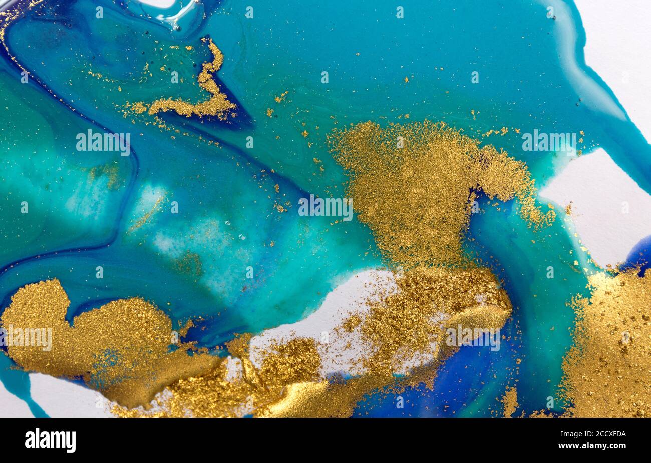 Gold and blue mixed inks splattered on white paper background Stock ...